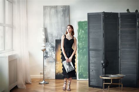 Обои на рабочий стол Модель Валерия в черном платье и с журналом в руках стоит в комнате обои