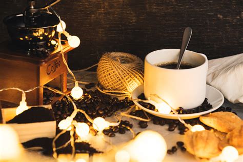 커피 컵 커피 분쇄기와 커피 콩 테이블에 지상 분말 사이드 뷰 뜨거운 커피와 패스트리 오래 된 부엌 테이블 소박한 배경 개념 리드 문자열 조명 커피 컵과 커피 분쇄기 0명에