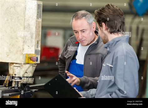 Engineer Showing Apprentice How To Use Cnc Tool Making Machine Stock Photo Alamy