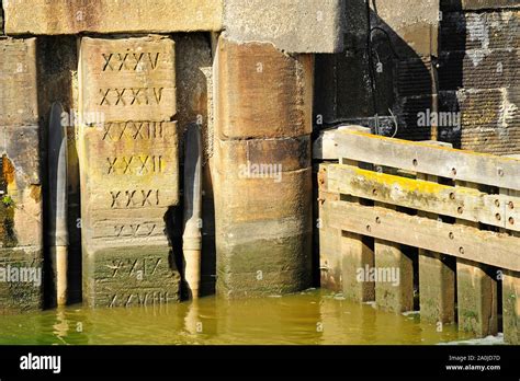 Roman Numerals Carved Into Stone Water Depth Marker On Docks Quayside