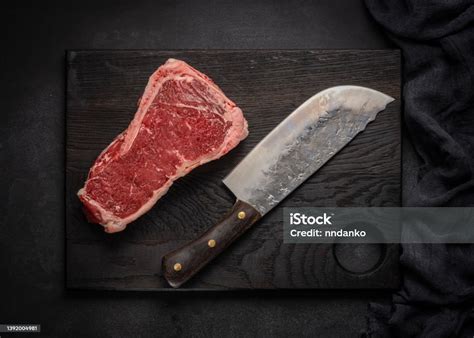 뼈에 쇠고기 고기의 원시 육즙이 많은 조각은 검은 색 배경의 나무 커팅 보드에 놓여 있습니다 0명에 대한 스톡 사진 및 기타 이미지 Istock
