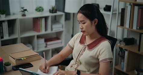 집에서 일기에 메모를 하는 펜을 들고 책상에 앉아 있는 행복한 젊은 아시아 여성 20 24세에 대한 스톡 사진 및 기타 이미지 20 24세 Brand Name