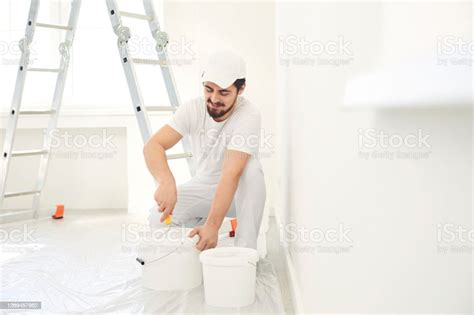 흰색 유니폼을 입은 남성 화가가 흰색 방에서 롤러를 손에 들고 일합니다 20 24세에 대한 스톡 사진 및 기타 이미지 20 24세 가정 생활 가정의 방 Istock
