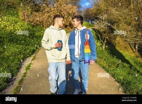 Young Caucasian Gay Couple Holding Hands And Walking In A Park