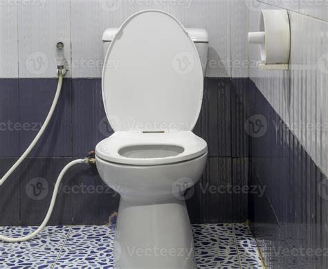 White Toilet Bowl With Bidet Sprayer In Resort Or Hotel Toilet Taken