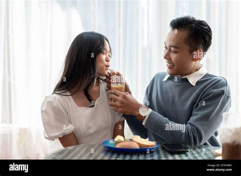 Adorable Cute Asian Couple Having A Lovely Date At A Cafe Having Food
