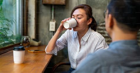 아시아 사업가와 사업가가 커피숍에서 사업 계획을 논의하고 있다 웃는 남자와 여자 친구들이 함께 이야기를 나누며 커피를 마시고 있다 중소 기업 및 레스토랑 개념입니다