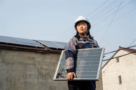 태양광 발전소가 설치된 집 앞에서 태양 전지판을 들고 있는 아시아 여성 엔지니어 전기 연료 및 전력 생산에 대한 스톡 사진 및 기타 이미지 전기 연료 및 전력 생산