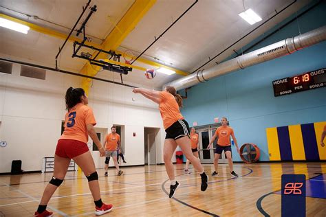 Download Free A Group Of Girls Playing Volleyball In A Gym Wallpaper