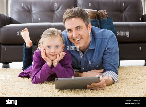 Caucasian Father And Daughter Using Tablet Computer In Living Room