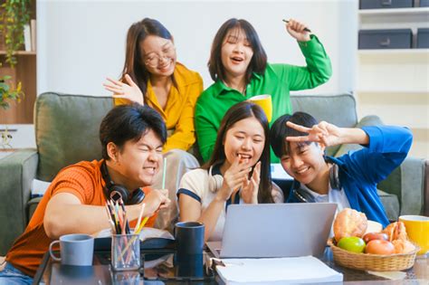 5명의 젊은 아시아 학생들이 캠퍼스에서 온라인 학습에 참여하여 연구 프로젝트에 협력합니다 그들은 과제를 통해 서로를 돕고 귀중한 경험을 쌓고 미래의 직업을 준비합니다