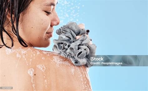 샤워 스펀지 여자는 물 비누 거품 스킨케어로 몸을 청소하고 웰빙 개인 위생 및 화장품을 모형 스튜디오 파란색 배경에 보관합니다 아시아 소녀 모델 미용과 목욕 25 29세에