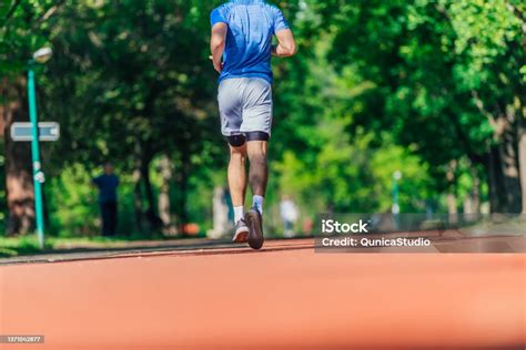 Close Up Feet With Running Shoes And Strong Athletic Legs Of Sport Man