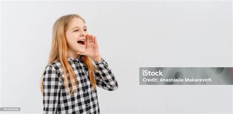 큰 소리로 정보 발표를 외치는 누군가를 부르는 넓은 열린 입 근처에서 손바닥을 들고 행복한 십대 소녀의 초상화가 흰색 배경 위에 서 있습니다 복사 공간 10 11세에 대한