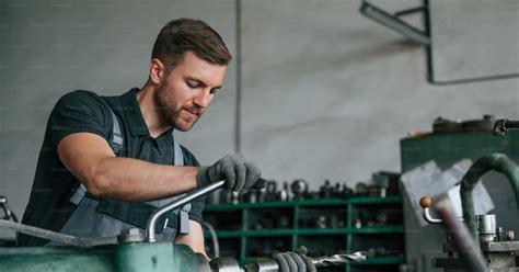 금속 작업 제복을 입은 남자는 실내에서 농업 기술의 세부 사항을 개발하고 있습니다 사진 Unsplash의 손 이미지