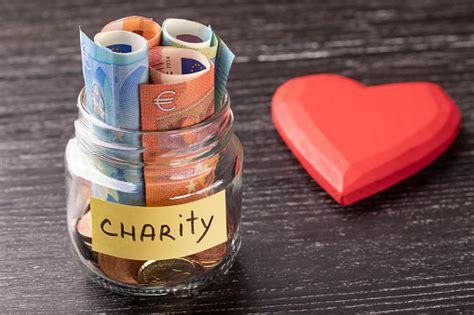 동전과 비문 자선 단체와 함께 유로 노트와 유리 항아리 함께 거 대 한 붉은 심장 Charitable Foundation에 대한