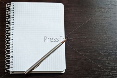 Фотография на тему Ручка и блокнот на деревянном столе Pressfoto