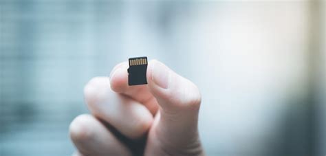 Premium Photo Young Man Is Holding A Tiny Memory Card In His Hand Text Space