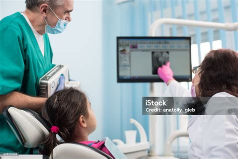 치과 치료를 하 고 도우미와 수석 소아 치과 환자 여자 치과 사무실에서 치과 X선 기계를 사용 하 여 사람들이는 모니터에 X선 이미지를 검사합니다 여자에 초점 치과 장비