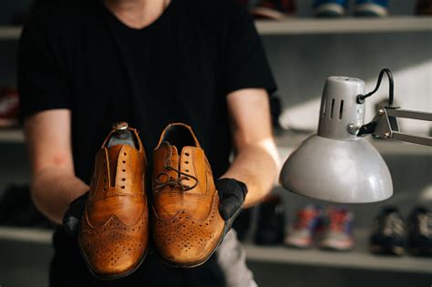 낡은 밝은 갈색 가죽 신발을 들고 검은 장갑을 낀 제화기술자 의 손의 클로즈업 프론트 뷰 가린 얼굴에 대한 스톡 사진 및 기타 이미지 가린 얼굴 가죽 고풍스런