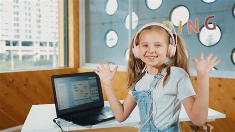 Premium Photo Smiling Girl Looking At Camera While Waving Hand With Laptop Placed Erudition