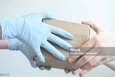 의료 고무 장갑에 골판지 상자를 들고 배달 남자 빠르고 무료 배달 전송 공간을 복사합니다 온라인 쇼핑 및 익스프레스 배송 클로즈업 흰색 배경 코로나바이러스에 대한 스톡 사진