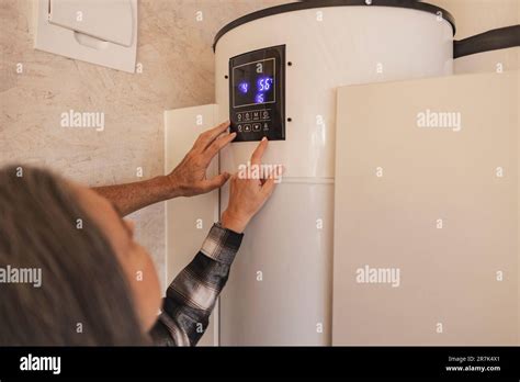 Man And Woman Adjusting Smart Home Thermostat Stock Photo Alamy