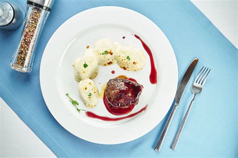 필레 미뇽 스테이크 미디논 스테이크 미디엄 희귀 베리 소스와 감자 뇨치가 파란색 식탁보에 흰색 접시를 얹고 고급 요리에 대한 스톡 사진 및 기타 이미지 Istock