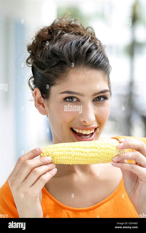 Female With Long Brunette Wavy Hair Worn Tied Up Wearing Orange Top