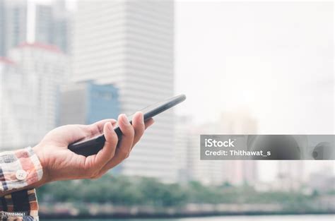 손 입력 스마트 폰과 일출 및 건물 배경과 도시에서 야외 응용 프로그램 장치와 터치 스크린 작업 검색을 사용하여 잘 생긴 남자를 닫습니다 세계를 연결하는 5g 기술 5g에