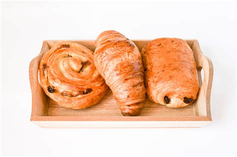 신선한 크로와상 초콜릿 빵과 시 나 몬 달콤한 롤 나무 접시 흰색 배경 전통적인 맛 있는 음식 프랑스 아침 식사와 영양 가득 차