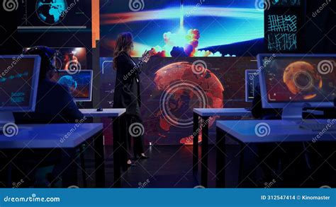 Earth Control Center Team Monitoring Space Ship On Big Screen Group Of People In Mission