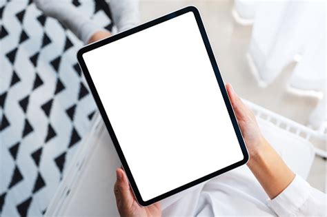 아침에 편안한 느낌으로 침실에 앉아있는 동안 빈 흰색 바탕 화면과 검은 색 태블릿 Pc를 들고 있는 여성 공란에 대한 스톡 사진