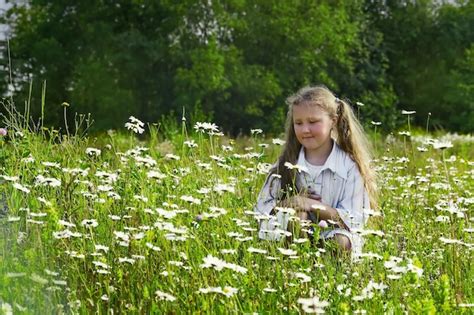 Premium Photo A Cute Girl With Pigtails Is Sitting In A Field With