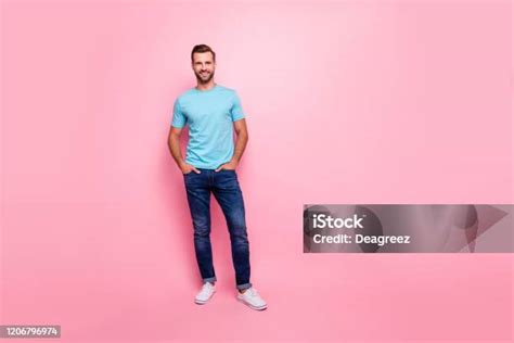 흰색 신발 고립 파스텔 색상 배경을 입고 청바지 주머니에 손을 들고 쾌활한 자신감 남자의 전체 길이 몸 크기 사진 T 셔츠에