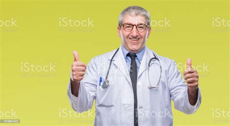 격리 된 배경 성공 기호 손으로 긍정적인 제스처를 하 고 웃 고 행복 한 엄지손가락에 잘생긴 수석 의사 남자 쾌활 한 식 우승자 제스처와 카메라를 보면 건강관리와 의술에