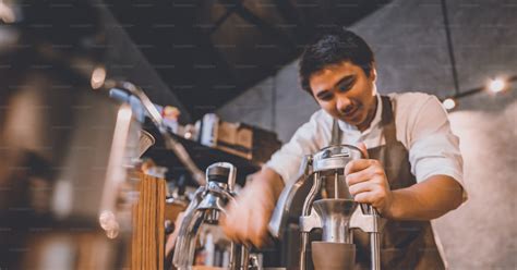 카페의 빈티지 나무 테이블 슬로우 바에 뜨거운 음료 에스프레소 블랙 커피를 만드는 전문 바리 스타 아침에 유리 컵에 카페인 추출 필터 드립 음료 커피 스타일 힙 스터