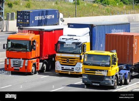 Front View Close Up Of Three Hgv Lorry Trucks And Articulated Trailers In