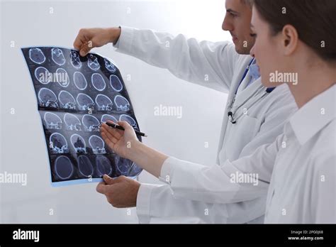Doctors Examining MRI Images Of Patient With Multiple Sclerosis In