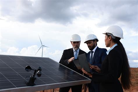 수석 사업가는 풍차 엔지니어와 태양 광 엔지니어가 녹색 에너지 전원 공급 장치를 설계합니다 녹색 에너지 및 재생 에너지 개념 풍차 엔지니어와 사업가는 풍력 터빈 농장에서