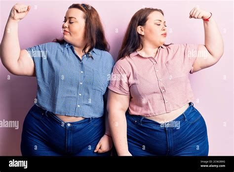Young Plus Size Twins Wearing Casual Clothes Showing Arms Muscles