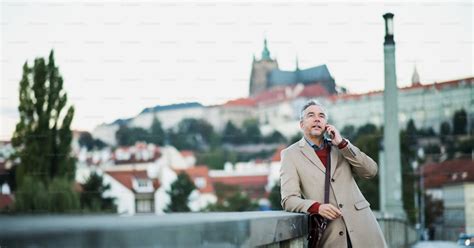 스마트폰을 가진 성숙한 사업가가 도시의 다리 위에 서서 전화를 걸고 있다 사진 Unsplash의 사업 이미지