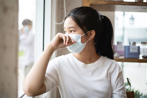 의료 용 마스크를 쓴 슬픈 태국 소녀가 창턱에 앉아 코로나 바이러스 전염병으로 인해 검역 중에 창 밖으로 보입니다 병원에 대한 스톡 사진 및 기타 이미지 Istock