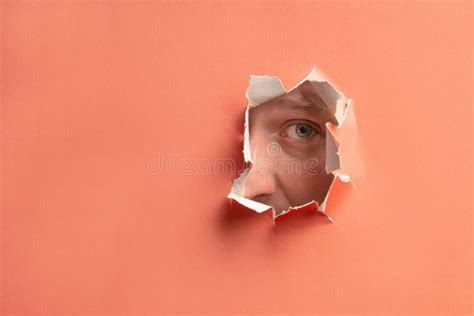 Peep Through Torn Paper Look Through A Hole In Paper Stock Photo