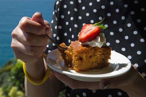 검은 물방울 무늬 드레스를 입은 여자가 크림과 딸기를 곁들인 케이크 한 조각을 맛본다 거품 내기에 대한 스톡 사진 및 기타 이미지 거품 내기 건강한 식생활 검은색