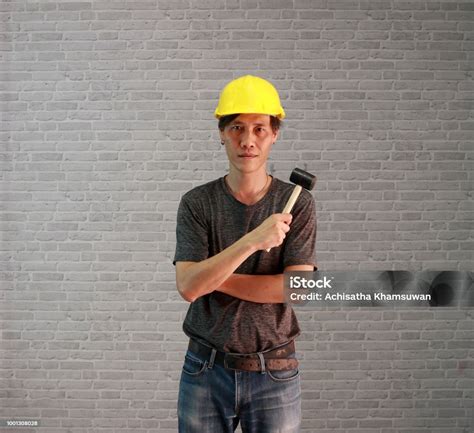 어두운 회색 T셔츠와 데님 청바지와 서 하 고 고무 망치로 가슴을 손잡고 포옹 기술자 남자 도자기 노란색 헬멧 T 셔츠에 대한 스톡 사진 및 기타 이미지 Istock