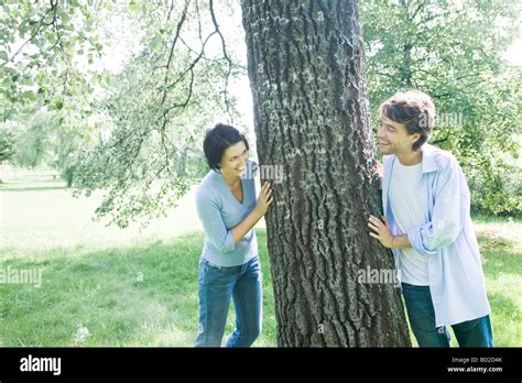 Couple Hiding Behind Tree Stock Photo Alamy