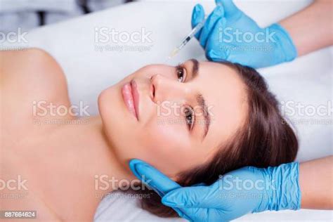 아름다움 주입입니다 여성 얼굴 근처 주사기와 의사의의 근접 촬영 얼굴 피부 리프팅 치료를 받고 하는 아름 다운 여자의 초상화