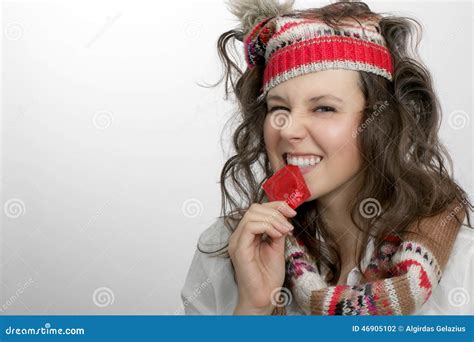 Girl With Knitted Hat And Scarf Holding With Teeth A Red Condom Stock