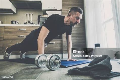 스포티한 남자는 집에서 운동하고 훈련한다 거실의 매트에서 운동을 하는 소년 45 49세에 대한 스톡 사진 및 기타 이미지 45 49세 가정 주방 가정의 방 Istock